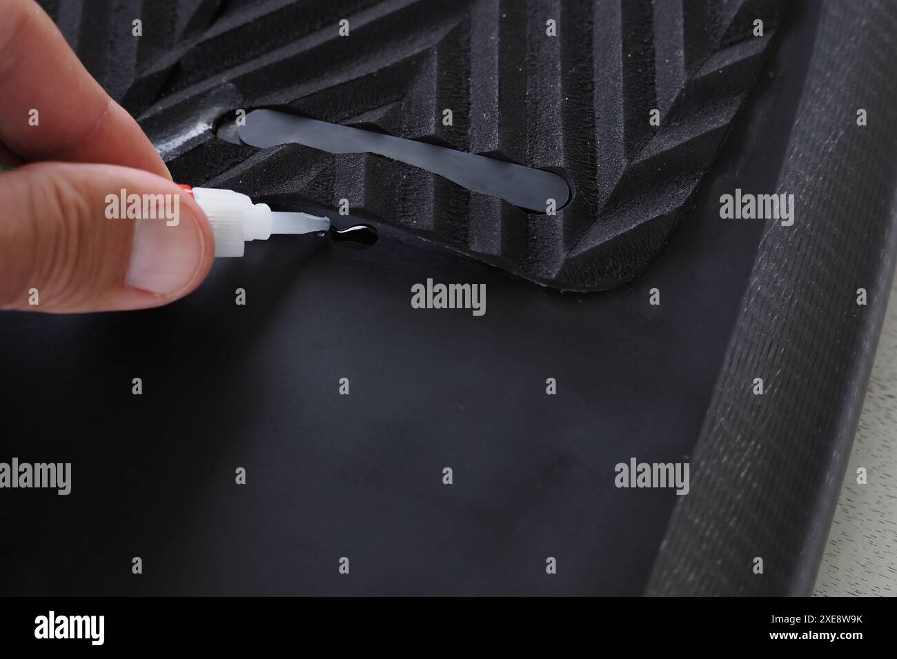 Close-up. Gluing tail traction pad of surfboard Stock Photo - Alamy