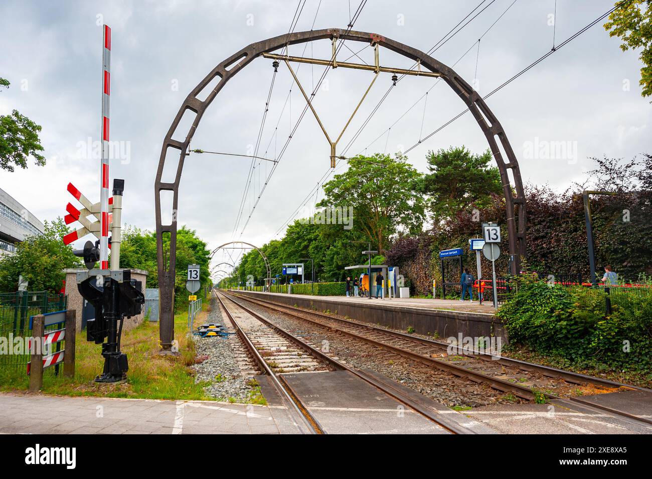 Railroad crossing and old electric overhead lines near the platform of ...