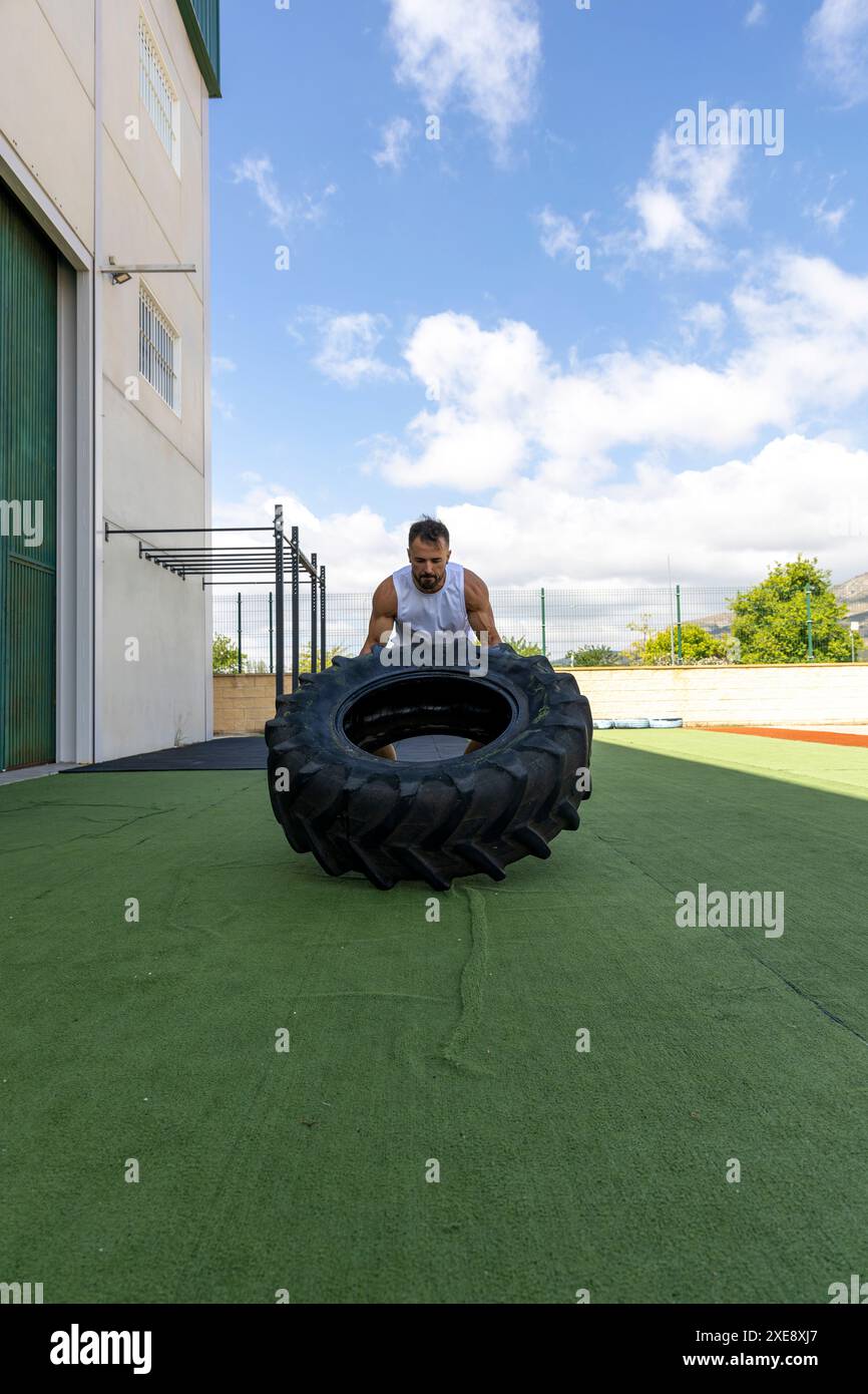 Strong man training crossfit with truck wheel Stock Photo - Alamy