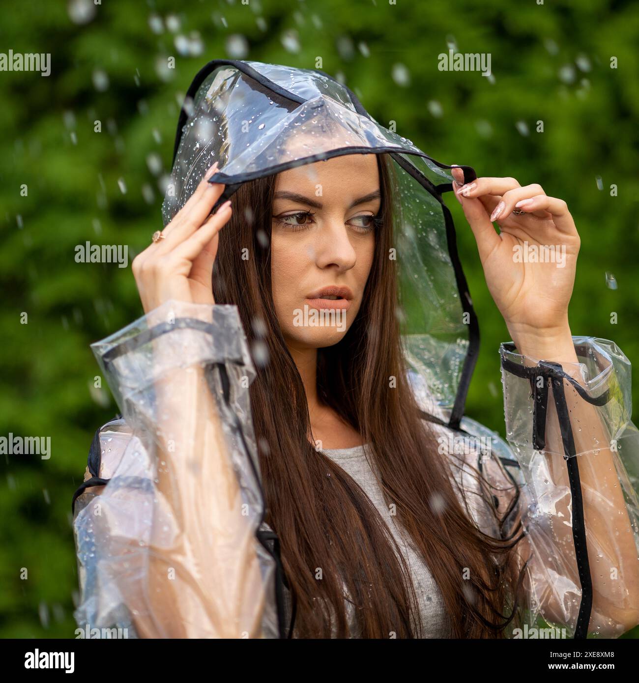 Young beautiful woman in hooded raincoat on rainy day Stock Photo - Alamy