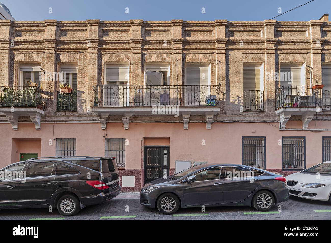 Facade of an old two-storey building with balconies and bars on the ...