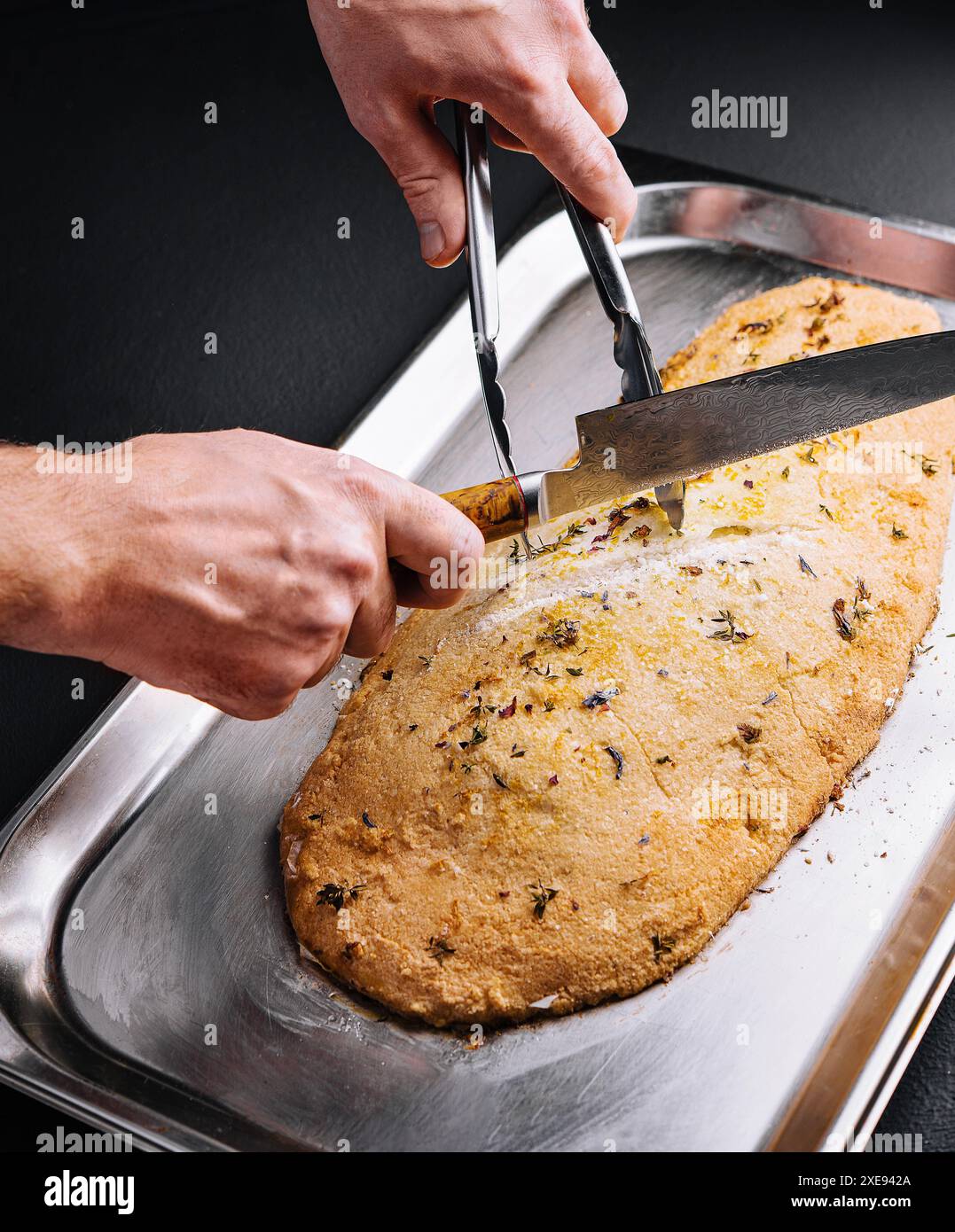 Baked fish, stuffed with herbs, in salt crust chef cuts Stock Photo - Alamy
