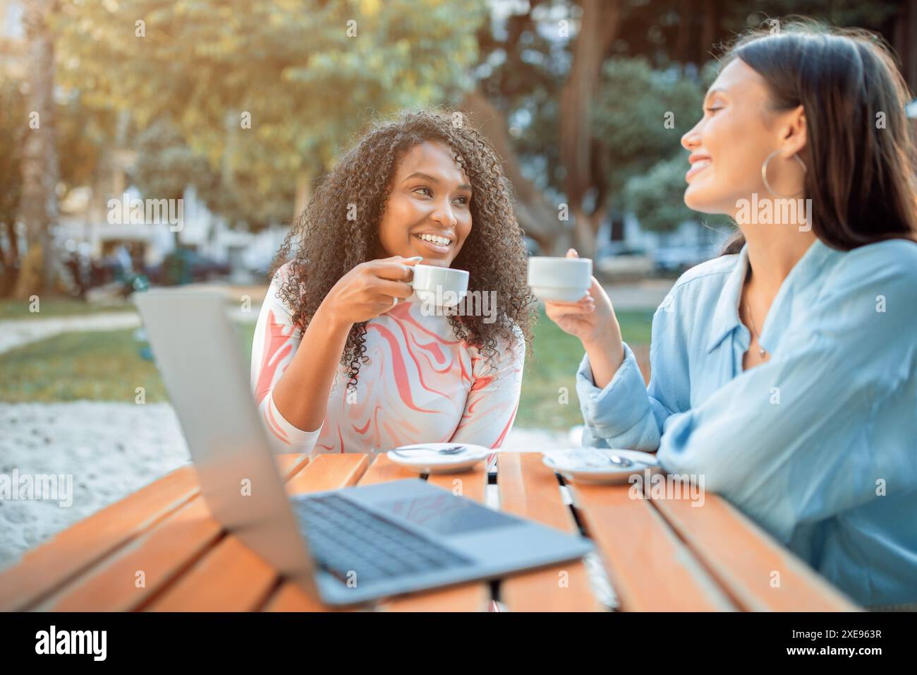 Two Women Enjoying Coffee and Conversation at an Outdoor Cafe Stock ...