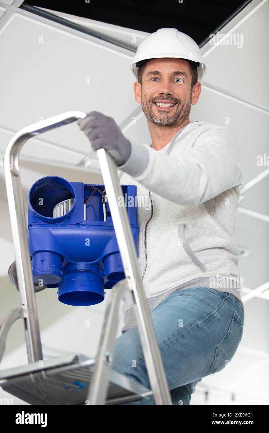 male contractor installing a ventilation system Stock Photo - Alamy