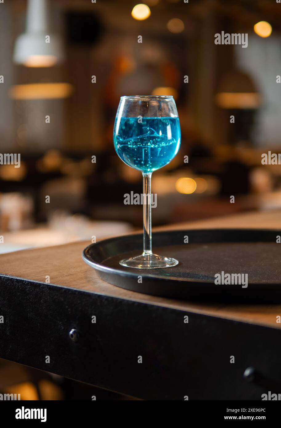 Glass of blue lagoon cocktail on bar counter Stock Photo - Alamy