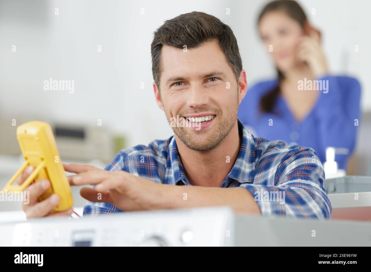 happy man checking socket voltage using multimeter Stock Photo - Alamy