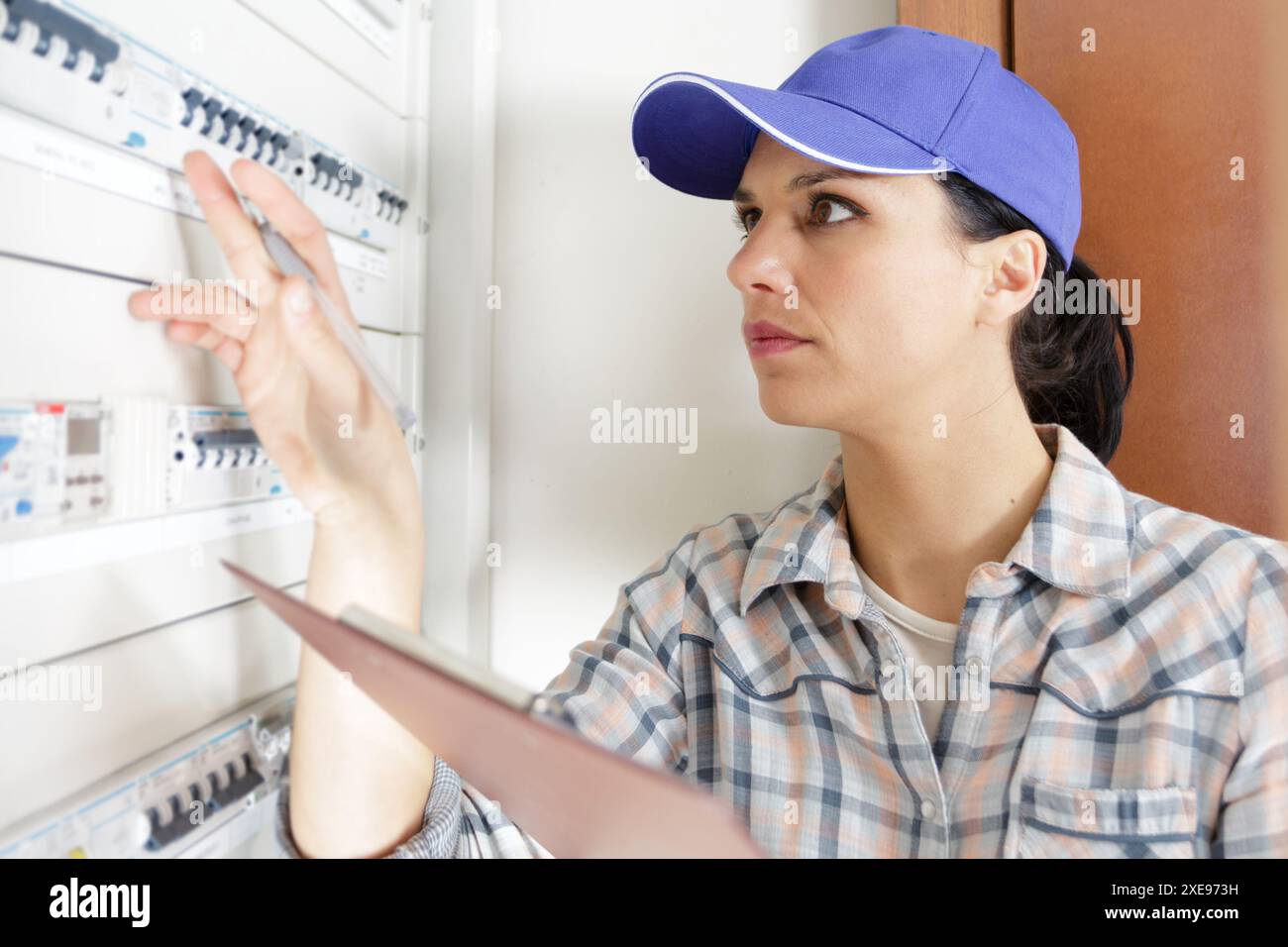 female engineer switches on circuit breakers in electrical box Stock ...