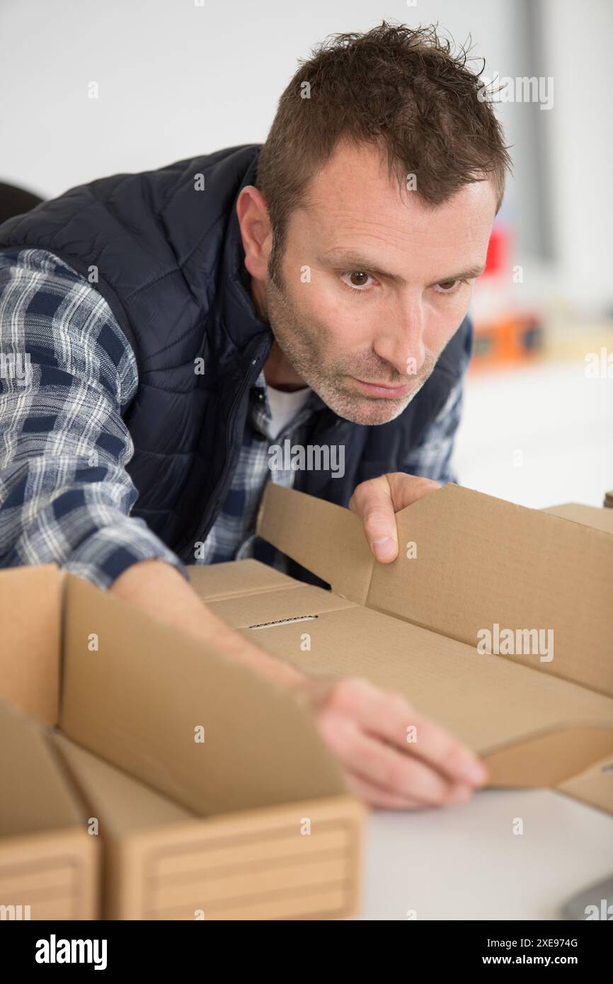 wokman constructing a cardboard box Stock Photo - Alamy