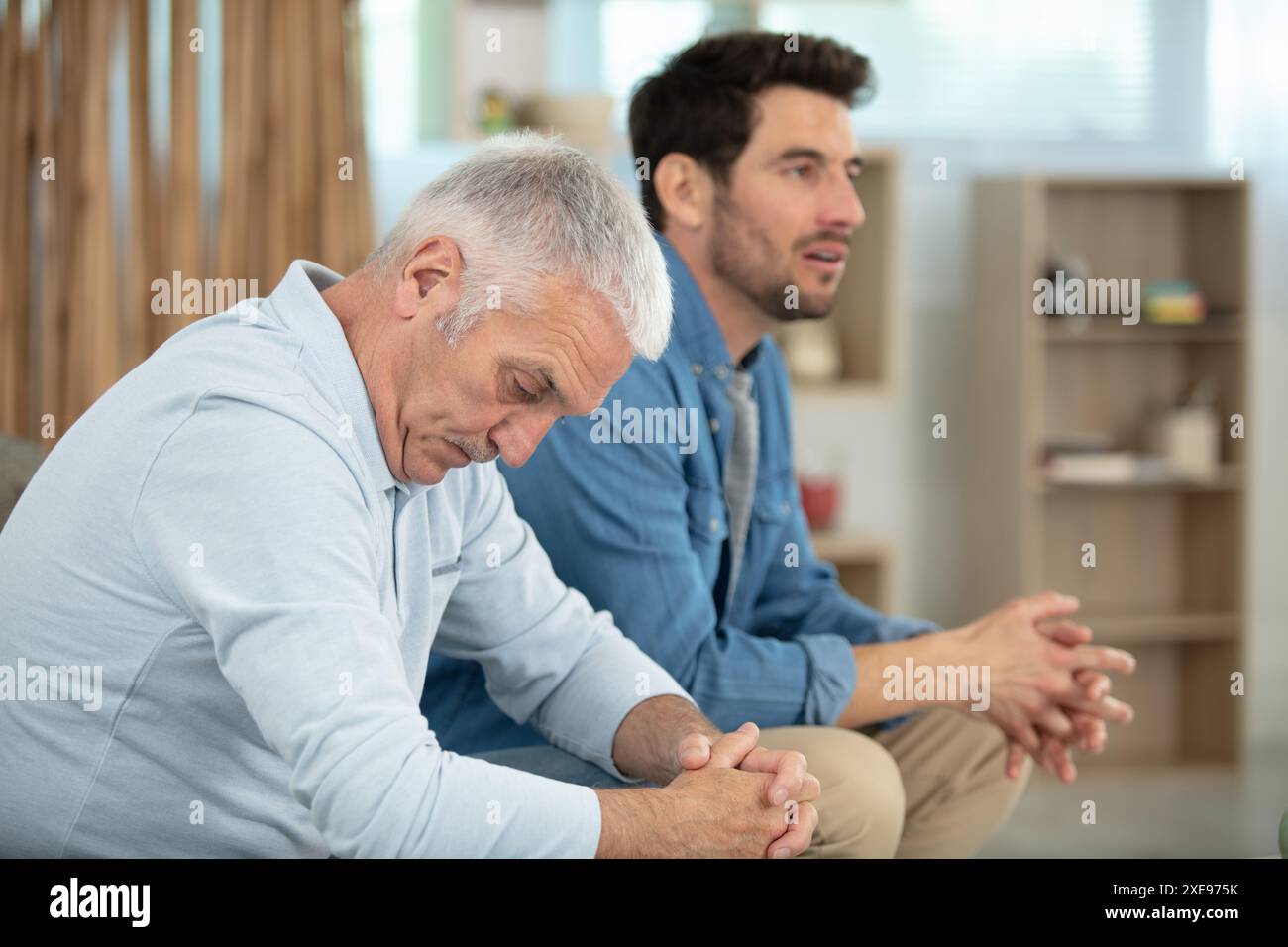 depressed father sitting next to grown up son Stock Photo - Alamy