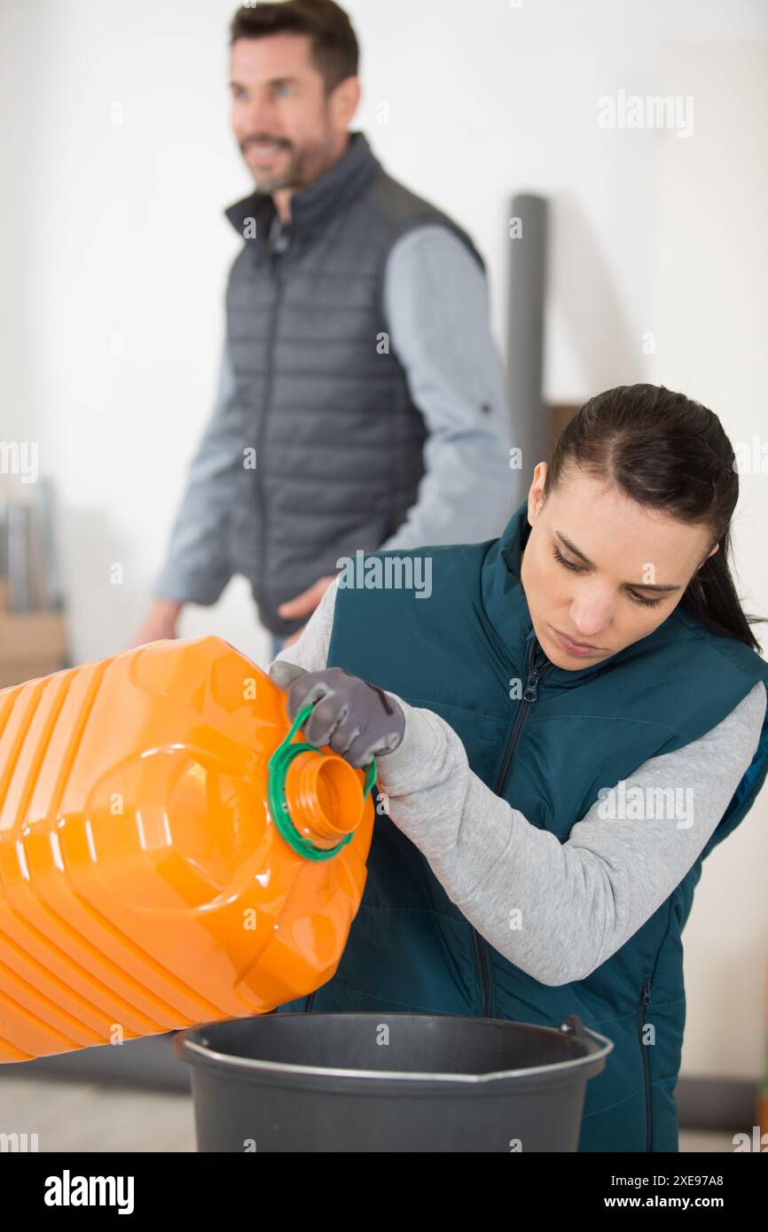 female worker pouring product from an industrial container Stock Photo ...