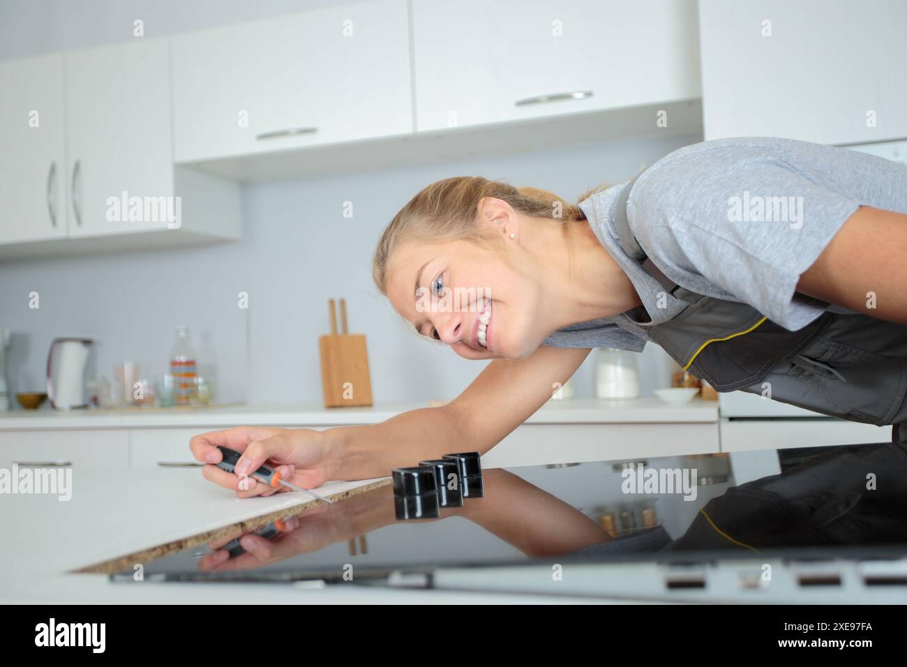 female technician installing a kitchen hob Stock Photo - Alamy