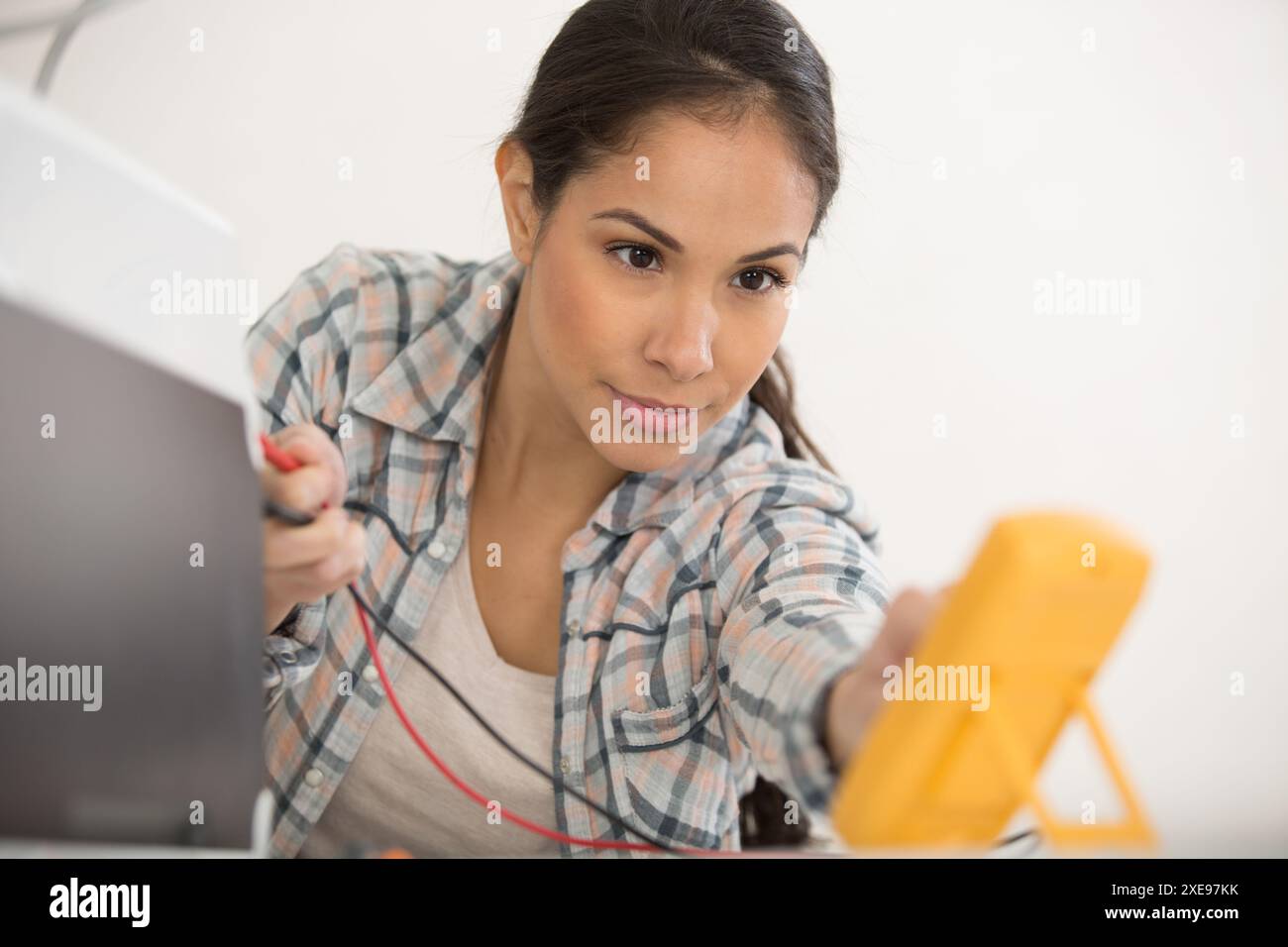 woman checking computer with a multimeter Stock Photo - Alamy
