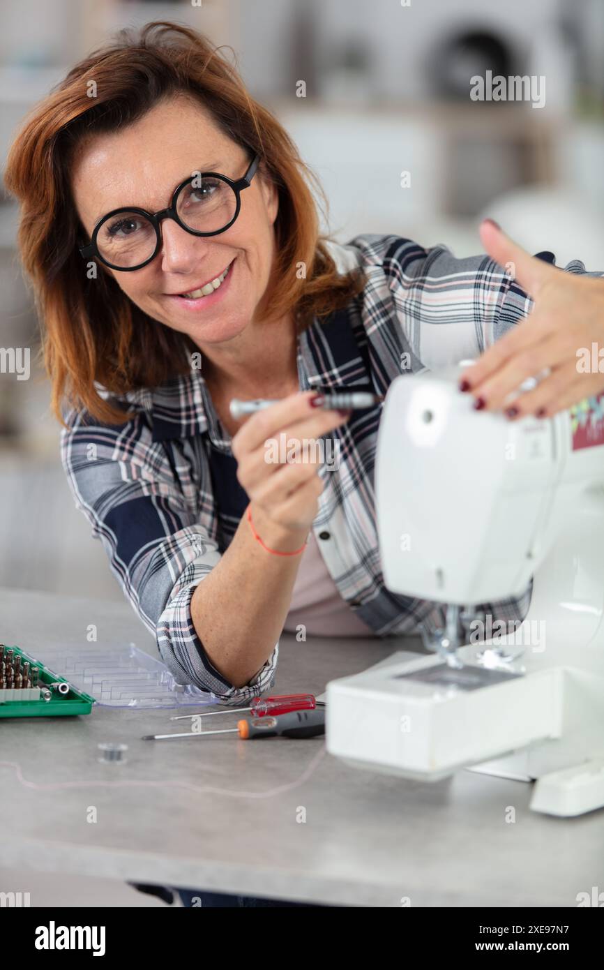 woman repairing sewing machine with a screwdriver Stock Photo - Alamy