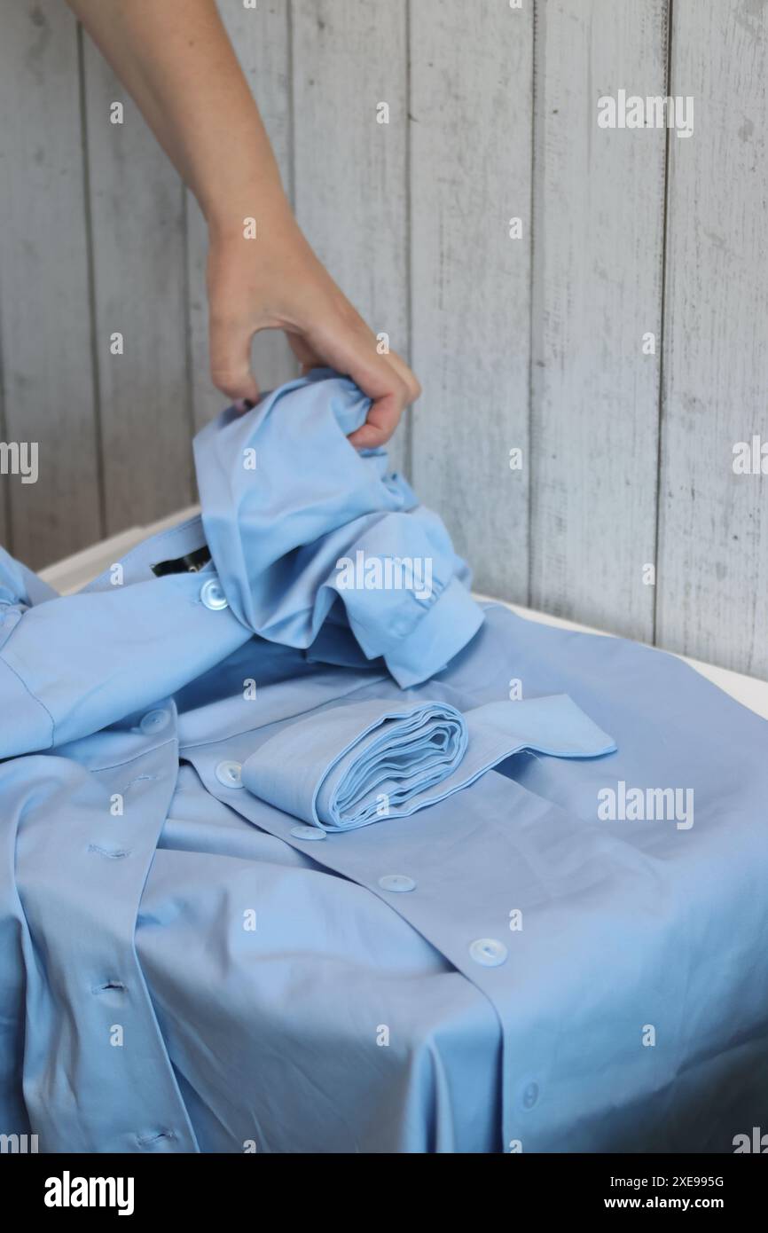 The woman makes a review of the summer dress of blue. Lays it on the ...