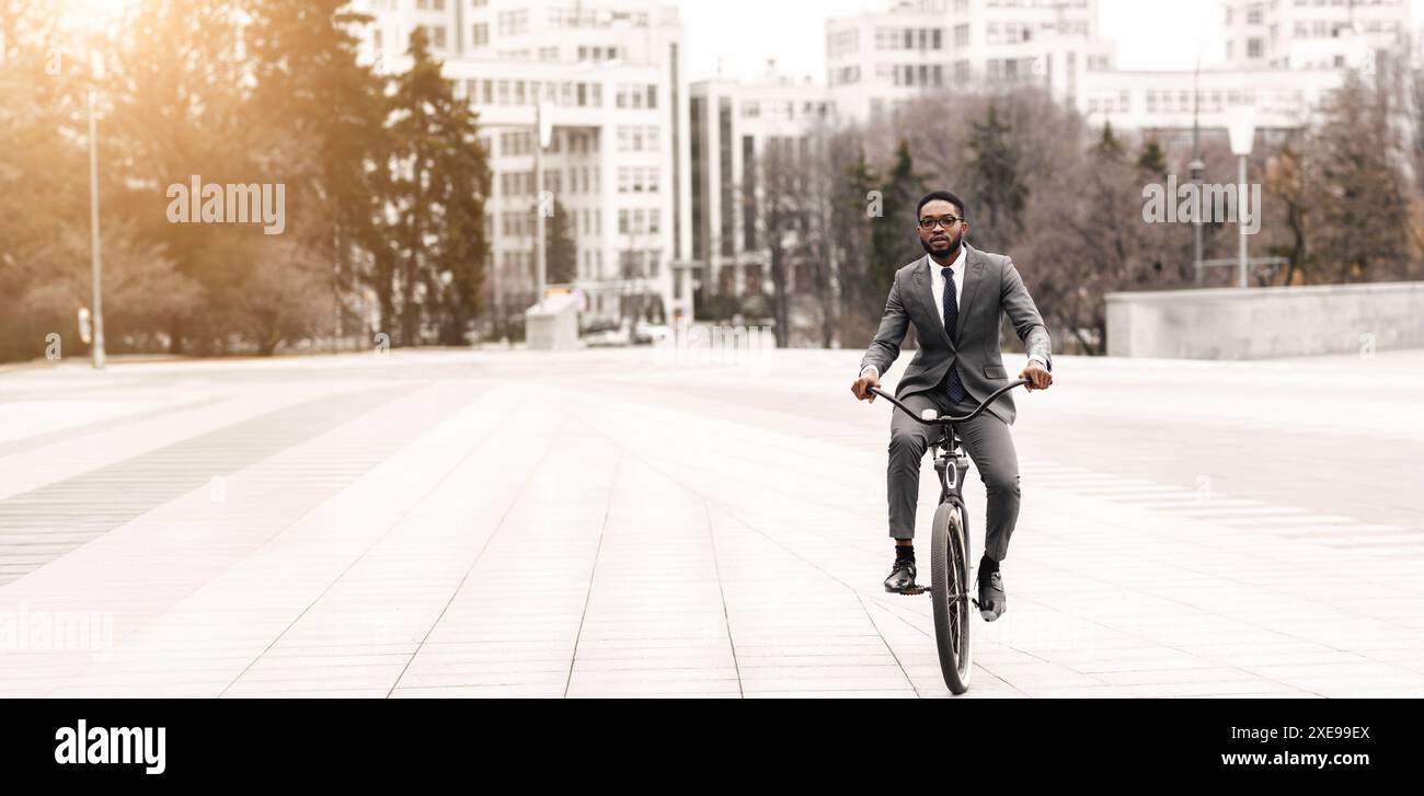 Executive African American man riding bicycle to office downtown Stock ...