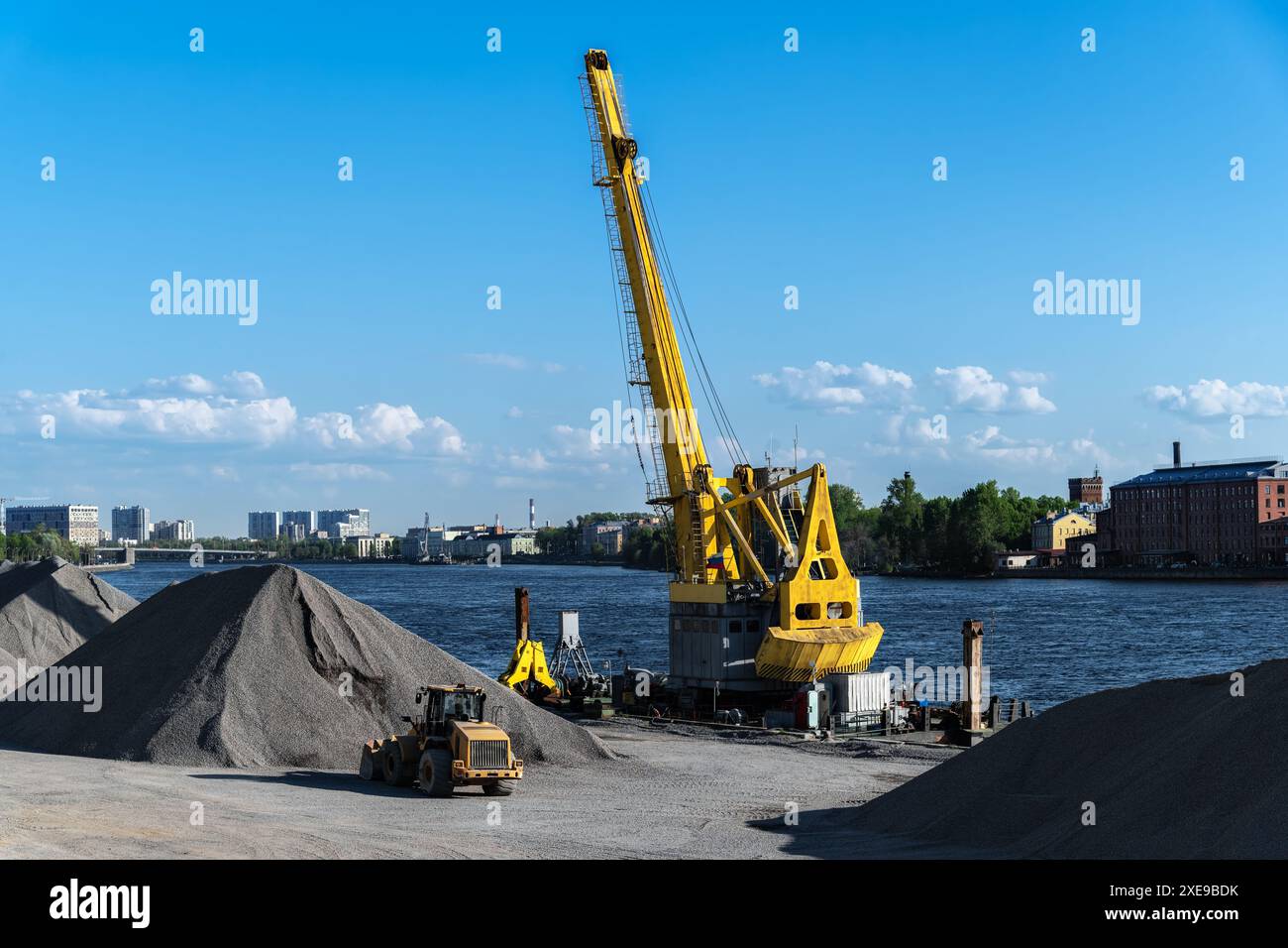 Construction site on the river bank with large mountains of rubble, a ...