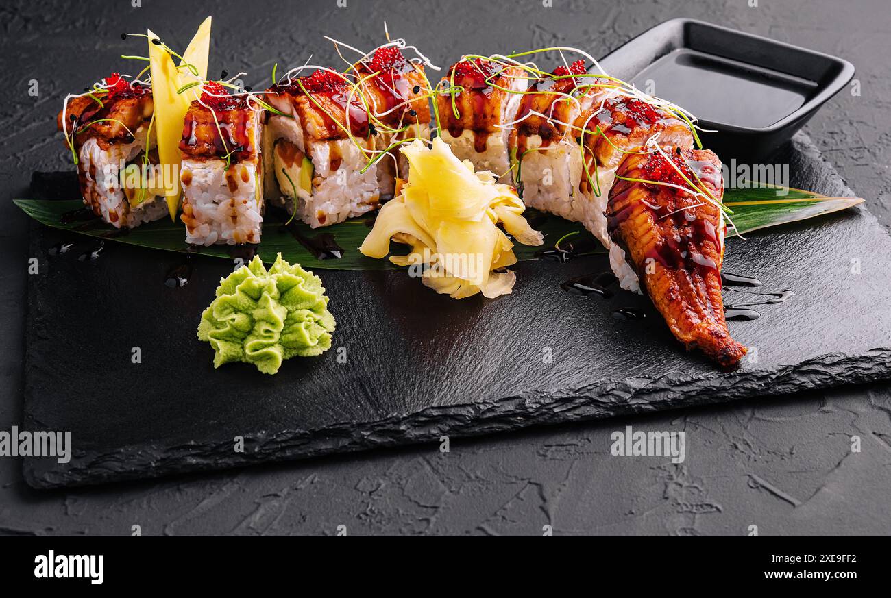 Canadian roll with eel, cheese cream and avocado on black Stock Photo ...