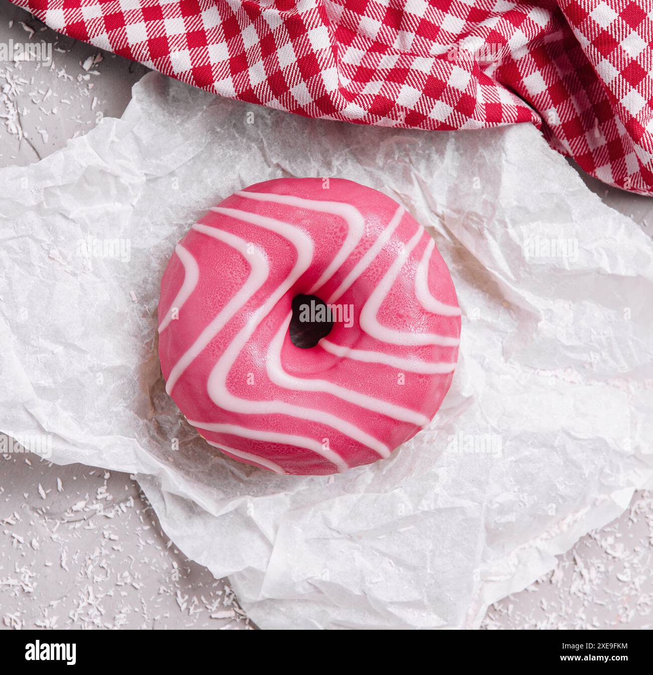 Strawberry donut covered with pink icing on baking paper Stock Photo ...