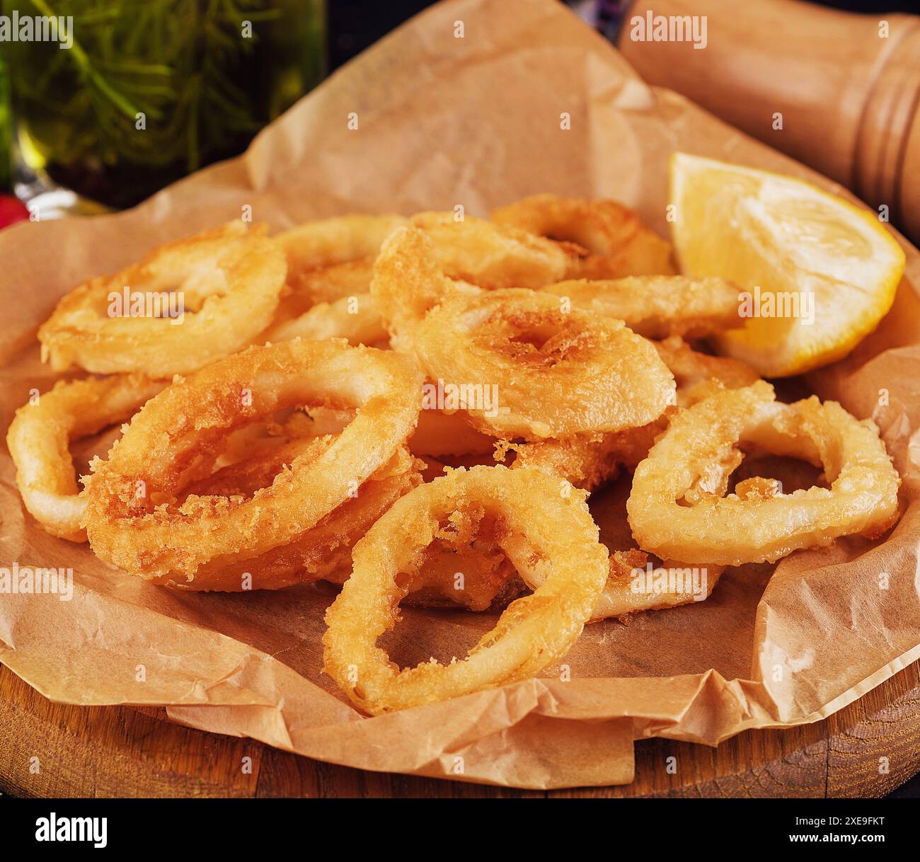 Oven baked breaded calamari rings served with lemon Stock Photo - Alamy