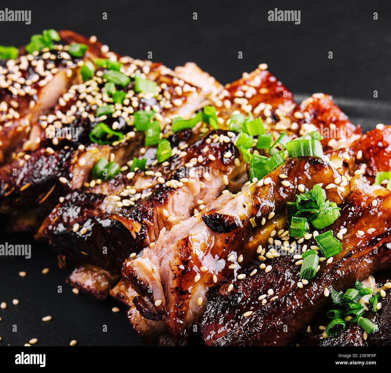 Sliced BBQ pork ribs on black plate Stock Photo - Alamy