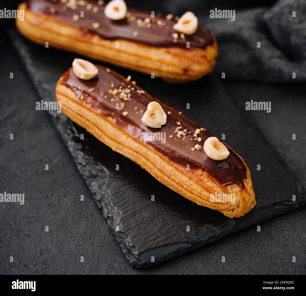 French eclairs with chocolate and hazelnuts Stock Photo - Alamy