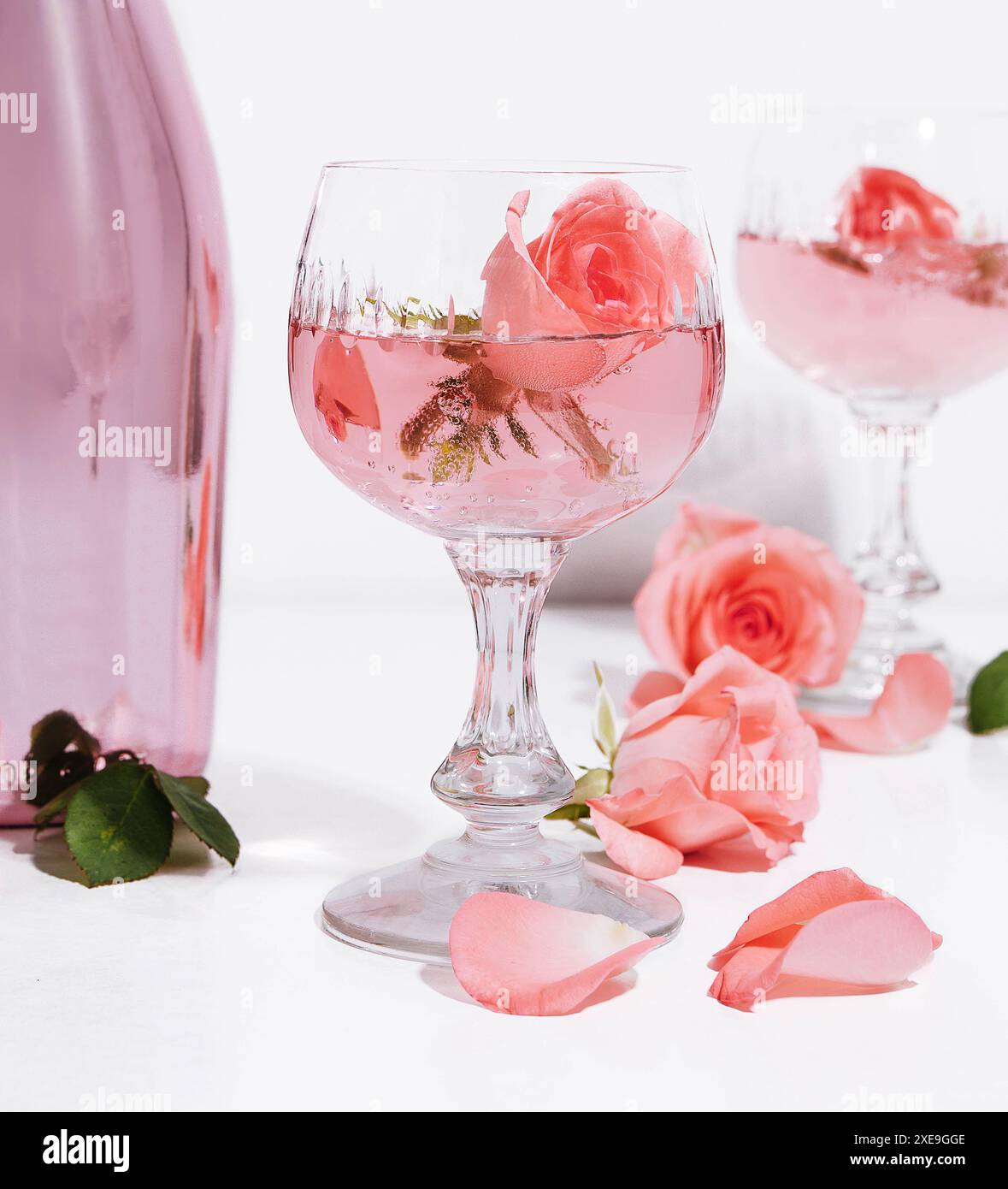Roses in pink champagne glasses with champagne bottle Stock Photo - Alamy