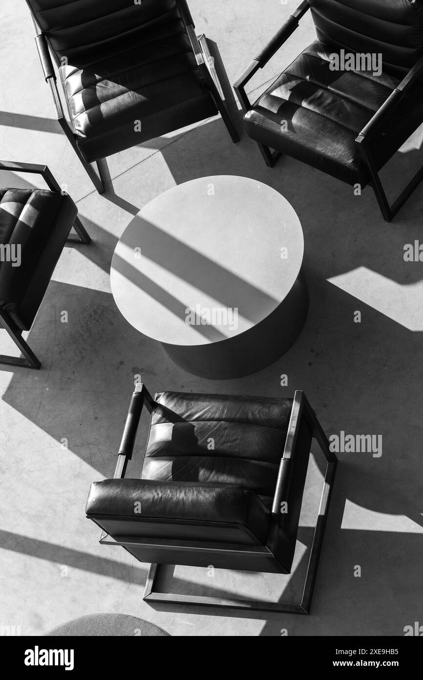 Black armchairs stand around white round table at meeting room, top ...