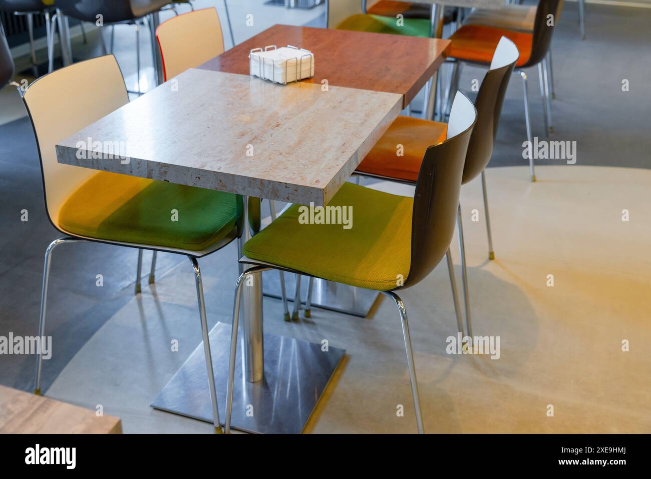 Fast food restaurant furniture, colorful chairs and tables stand in a ...