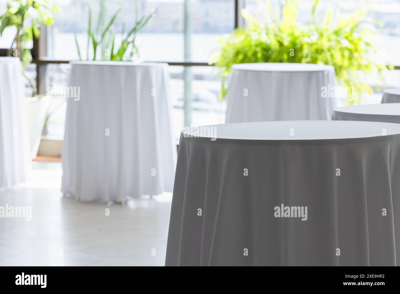 Round tables for the buffet are covered with white tablecloths ...