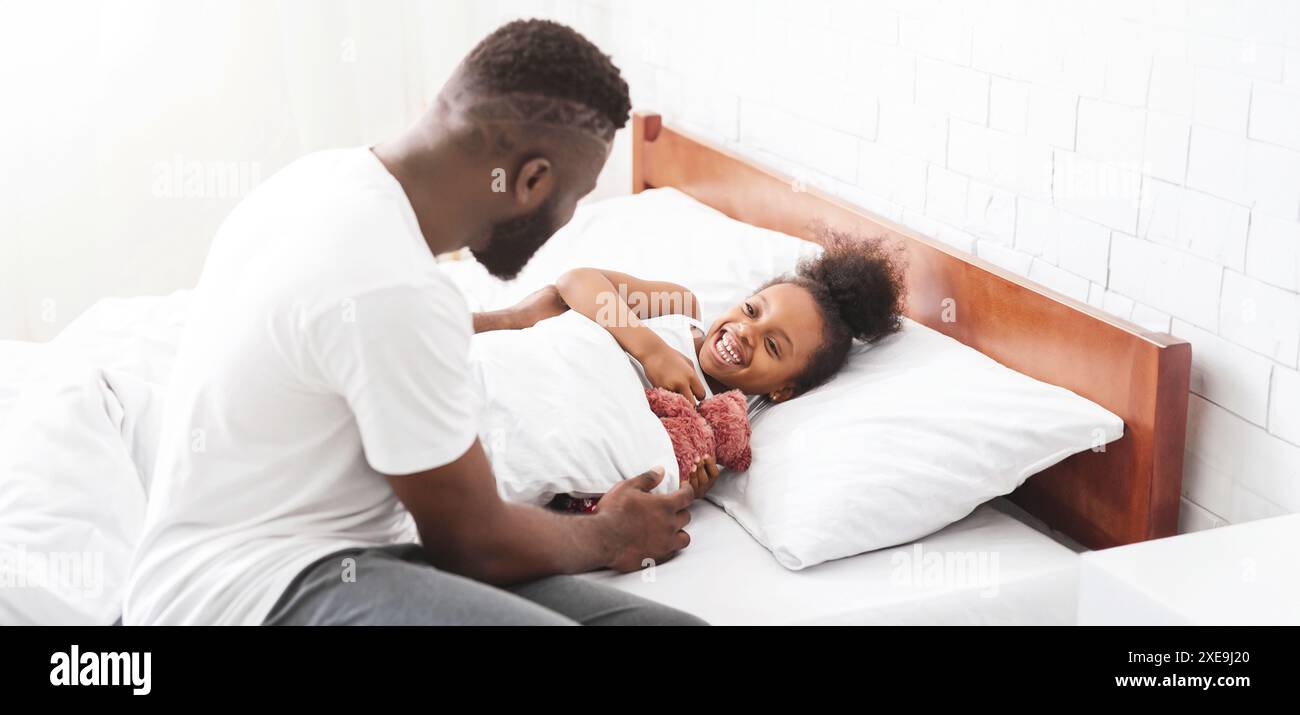 Father tucking daughter into bed hi-res stock photography and images ...