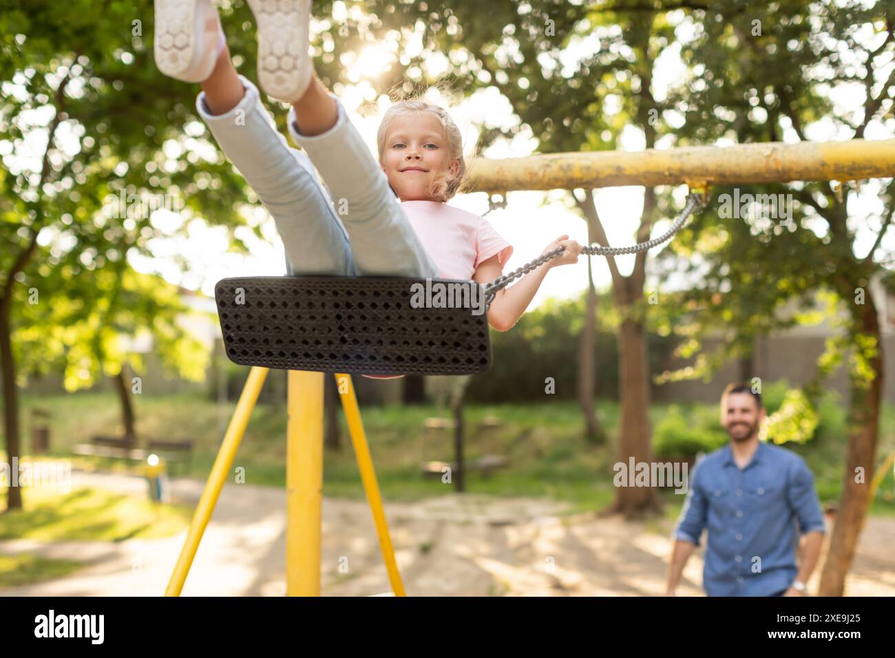 Happy Young Girl Swinging on a Playground Swing Set Stock Photo - Alamy