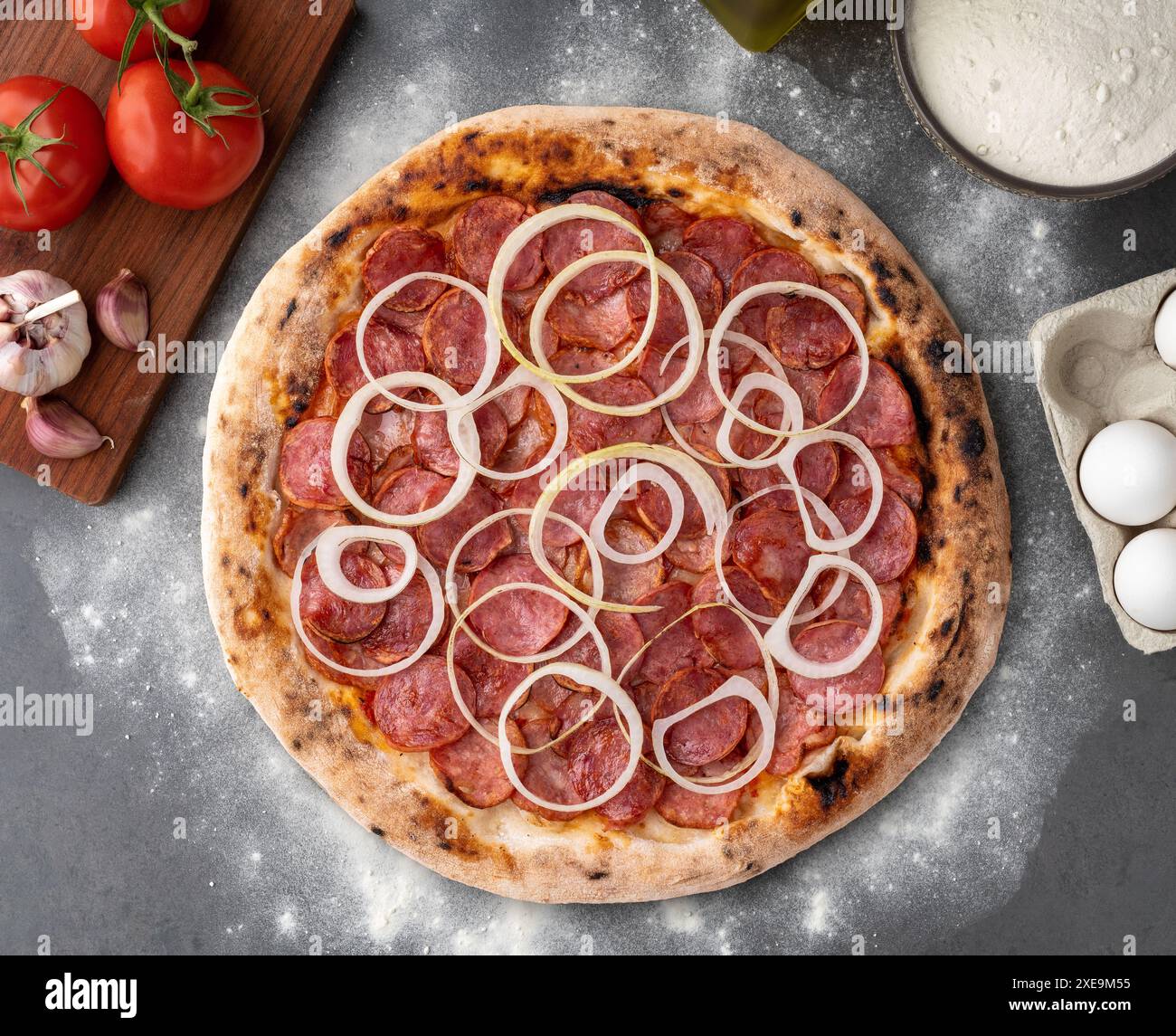 Calabrese sausage style pizza over stone background with ingredients ...