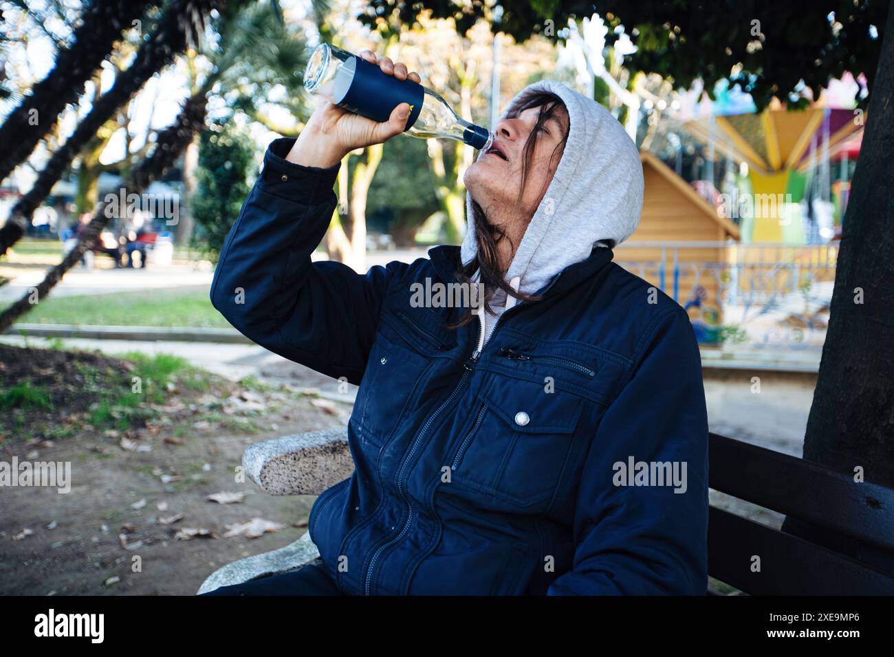 Man on bench is drinking alcohol. Alcohol addiction concept Stock Photo ...