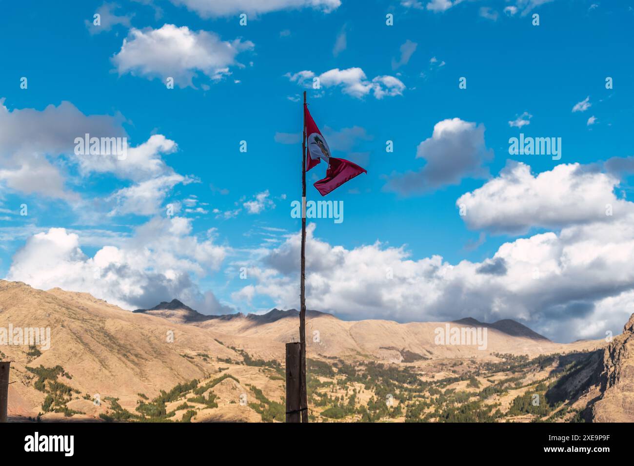 red and white flag on a flagpole flying in the Andes in Peru Stock ...