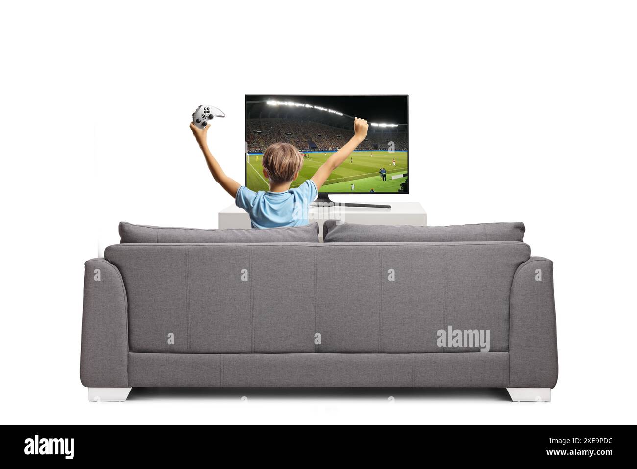 Rear view shot of a happy kid sitting on a sofa and playing a football ...