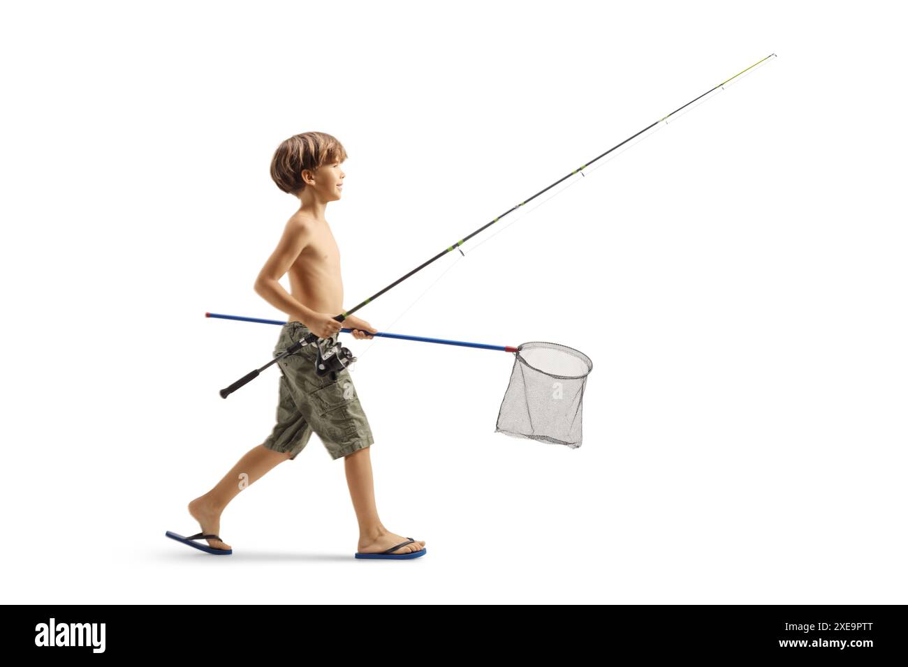 Full length profile shot of a boy carrying a fishing rod and net and ...