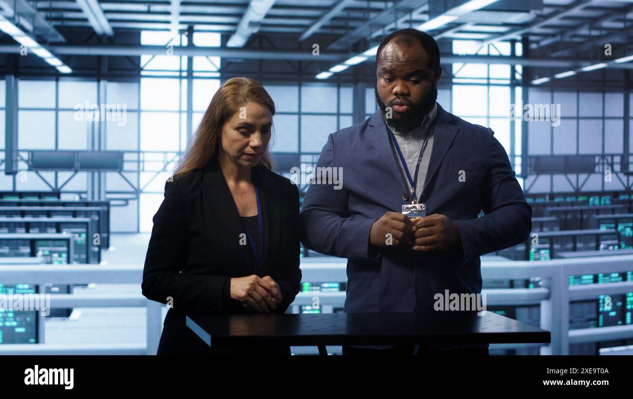 System administrators looking at holograms in data center, doing ...