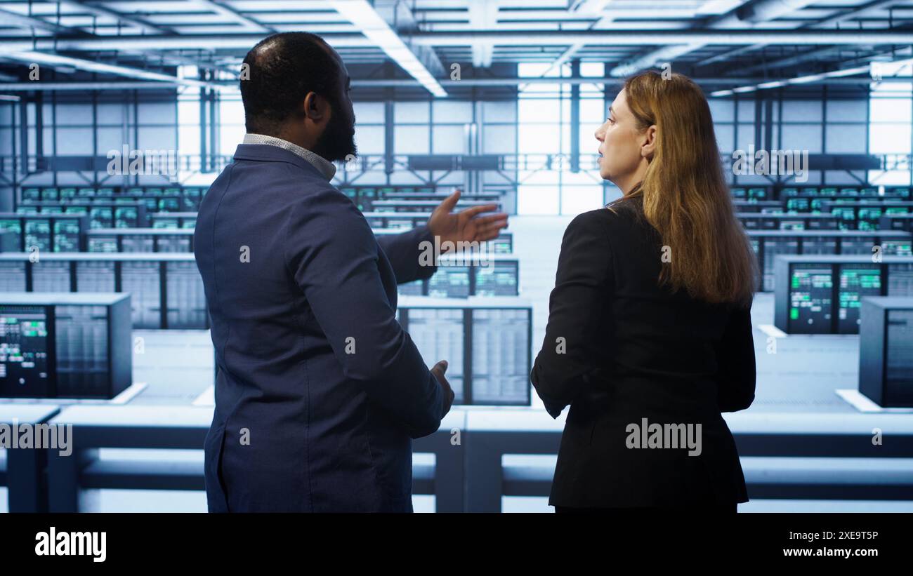 Data center engineer presenting equipment to inspector supervising ...