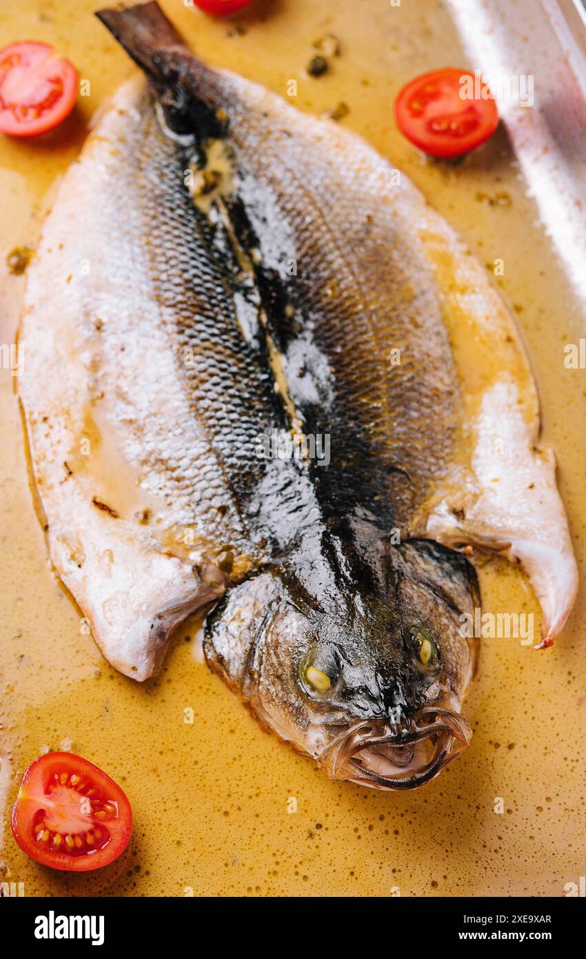 Grilled delicious fish.baked fish with tomatoes Stock Photo - Alamy