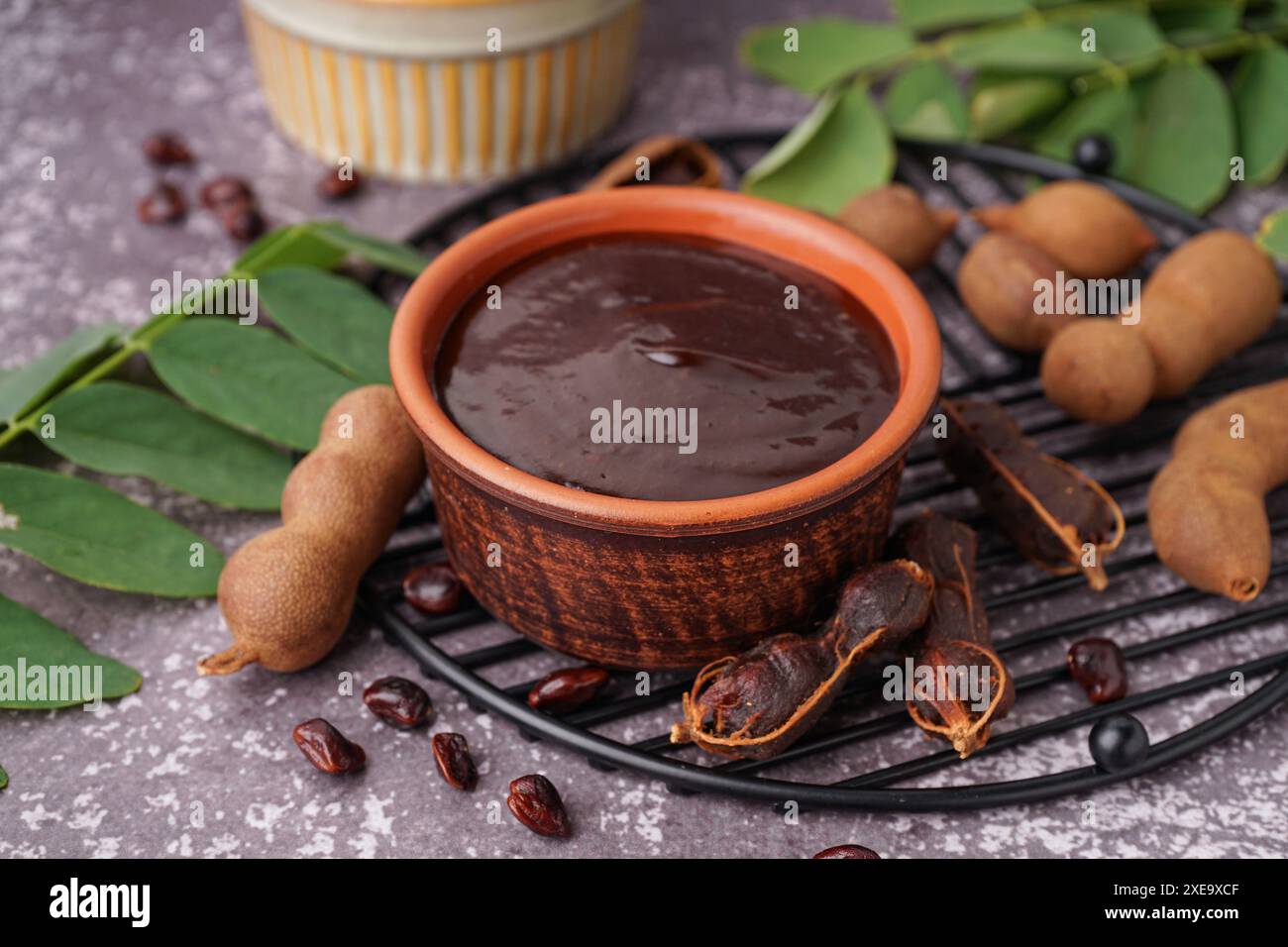 Bowl of tasty tamarind jam and fruits on grey background Stock Photo ...
