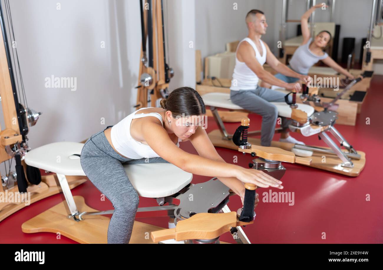 Sportive young girl training her arms turning handle of exercise ...