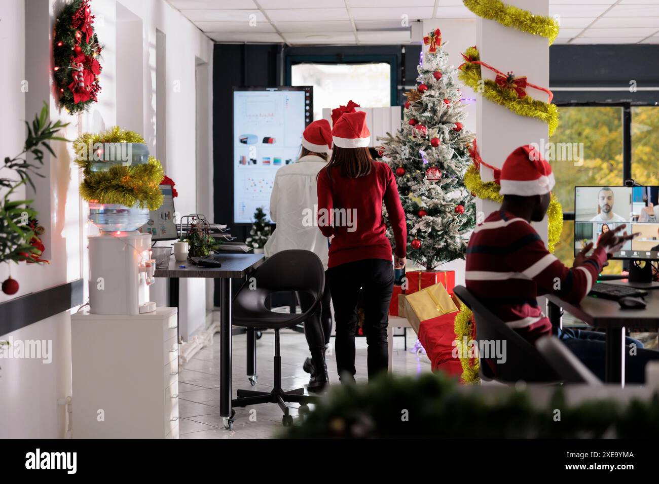 Work colleagues wearing santa claus hats hi-res stock photography and ...