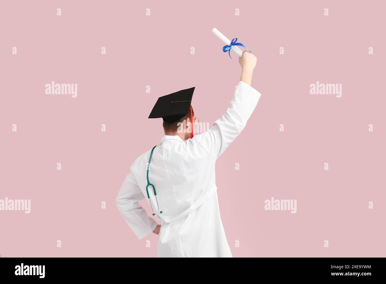 Male medical graduate with diploma and stethoscope on pink background ...