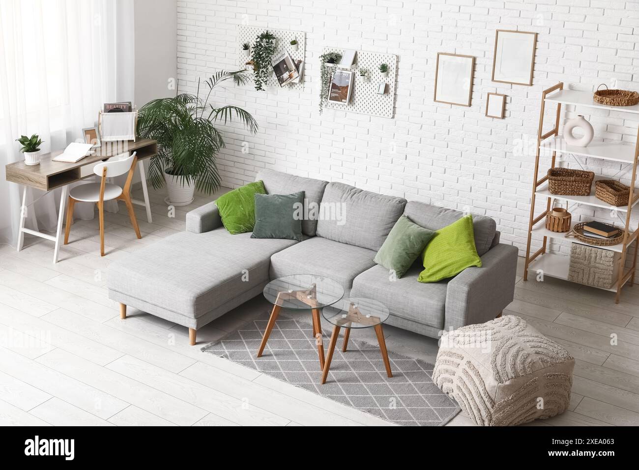 Living room with grey sofa, workplace, coffee table and pegboard Stock ...