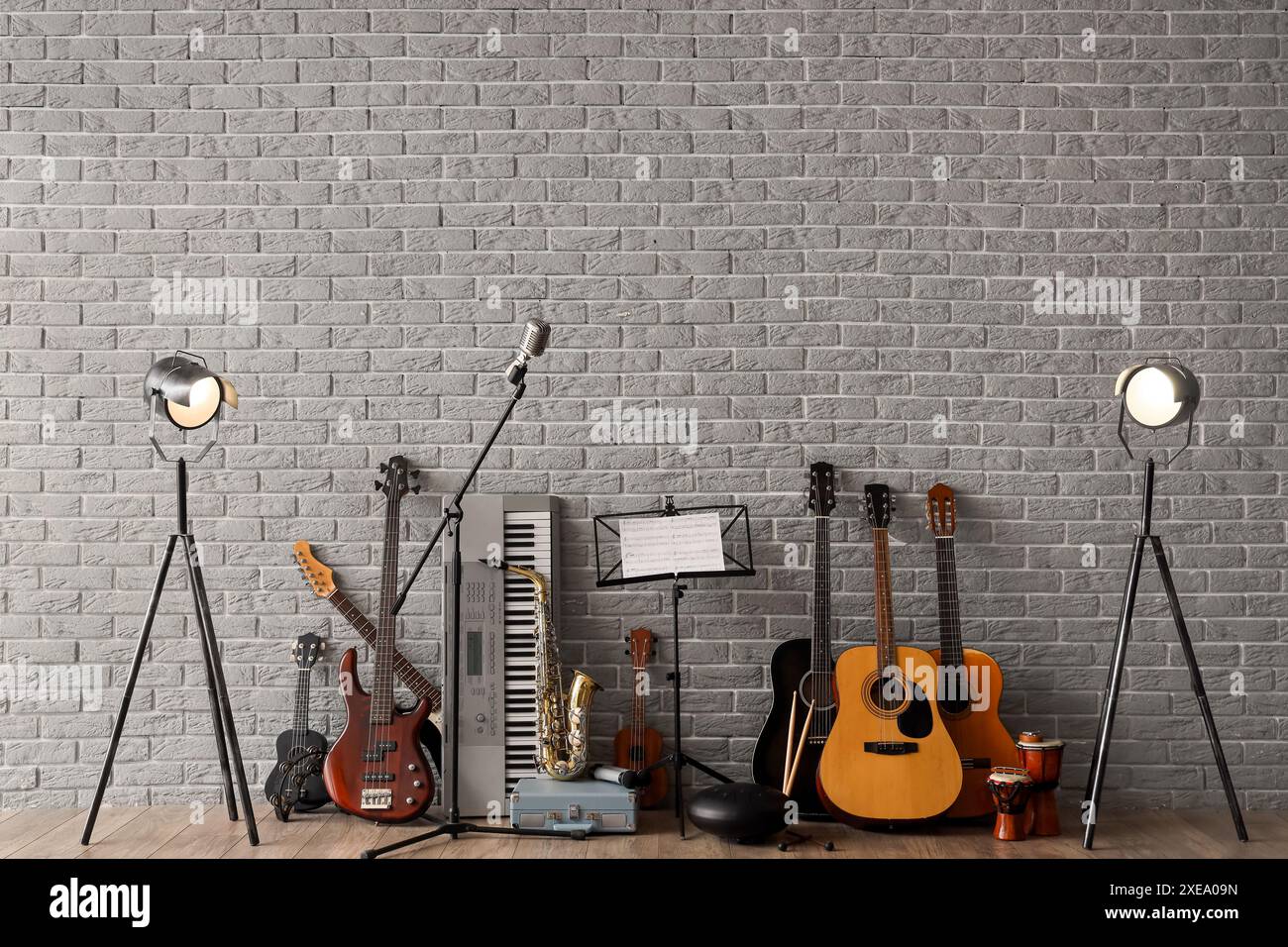 Different musical instruments near grey brick wall Stock Photo - Alamy