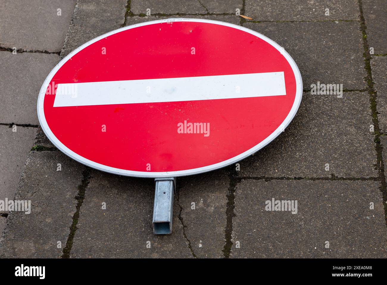 A road sign lying on the sidewalk no entry Stock Photo - Alamy
