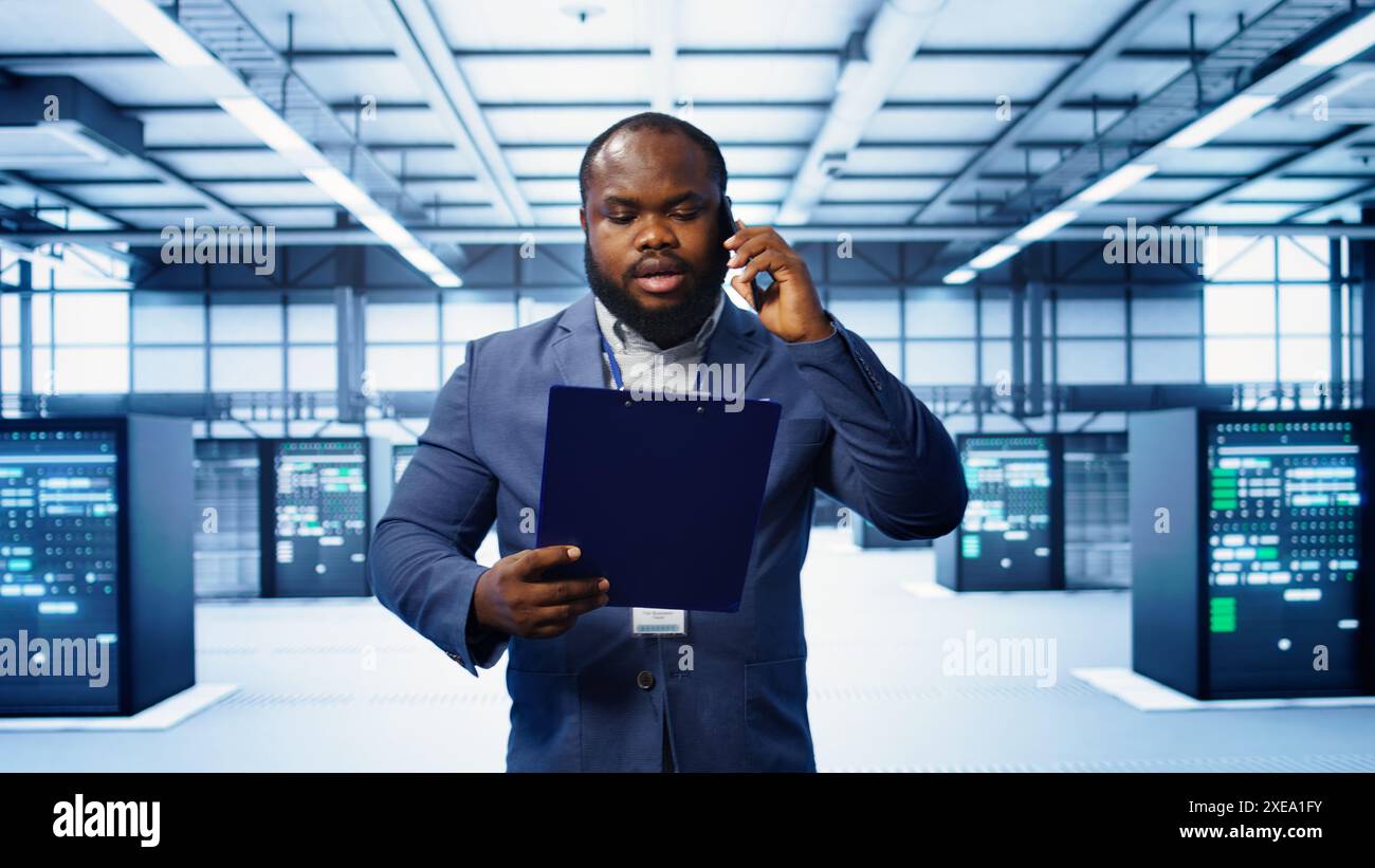 IT professional looking over data center checkup checklist paperwork ...