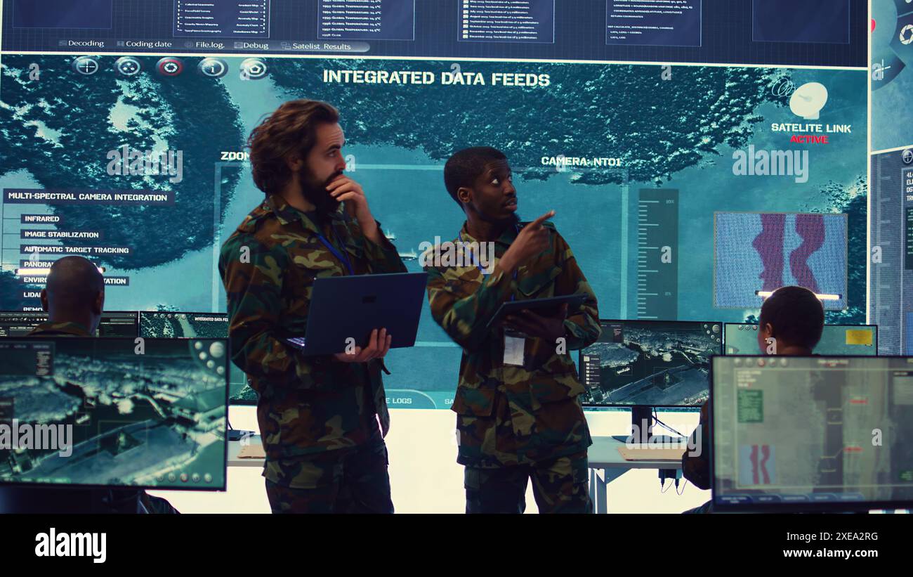 Diverse team of infantry unit leader and commander gather intelligence via radar surveillance ...