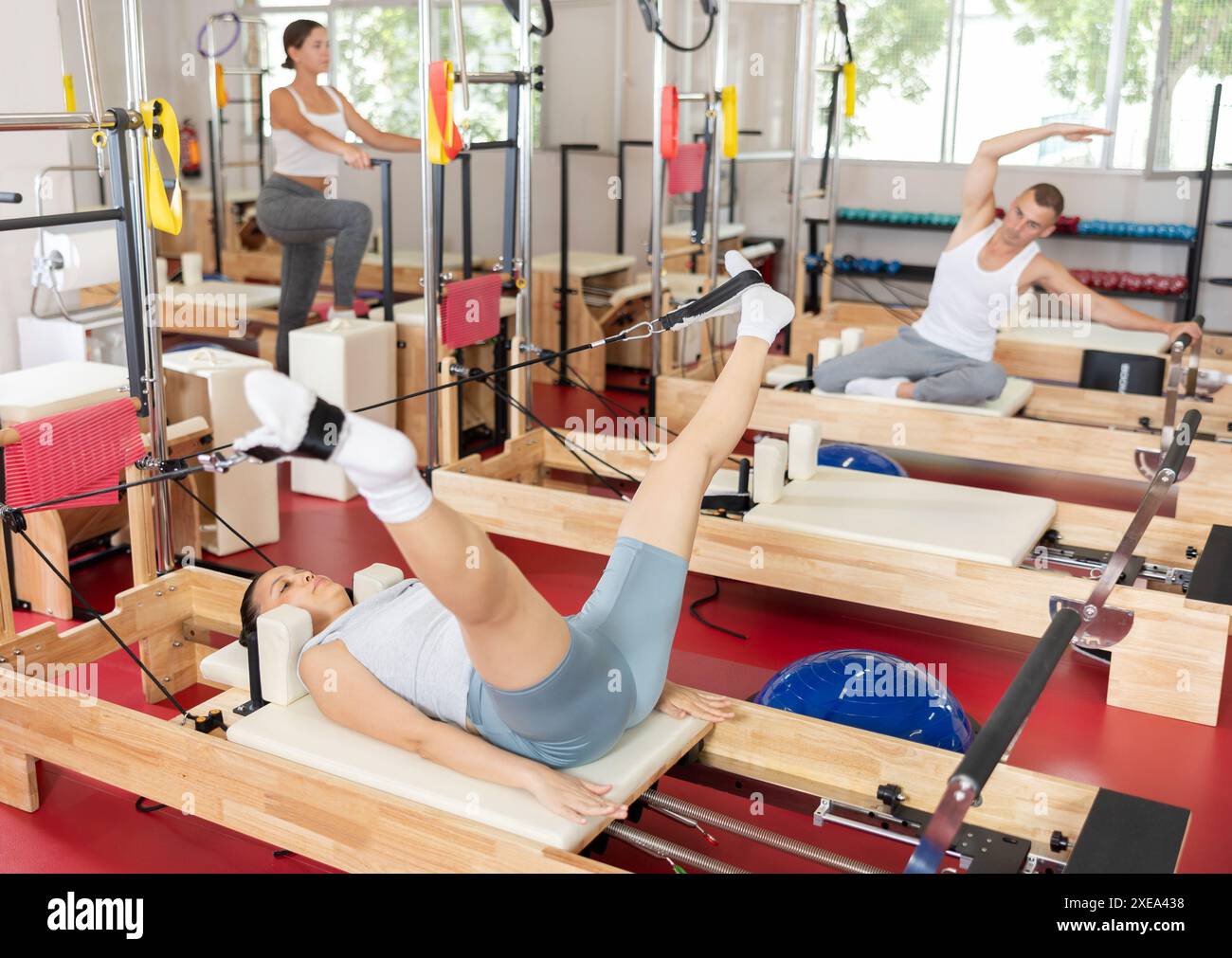 Young girl doing leg exercises on cable reformer device Stock Photo - Alamy