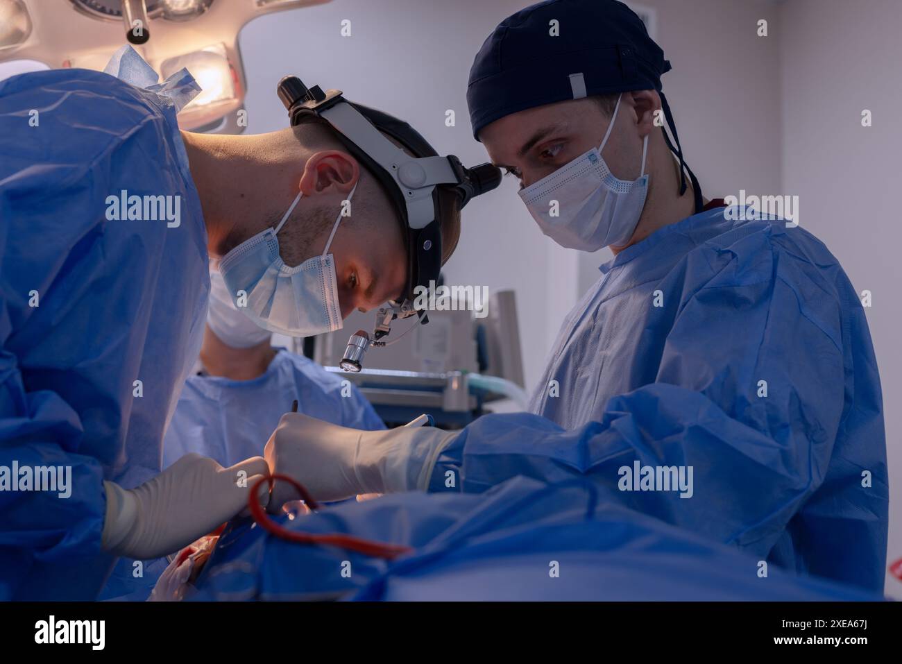 Two surgeons performing a medical operation in a hospital operating ...